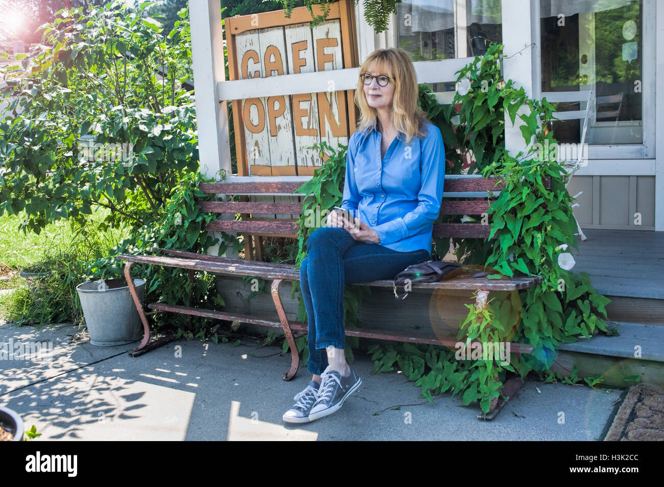 Woman resting on cafe bench Stock Photo - Alamy
