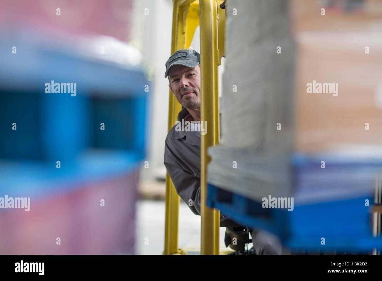 Forklift driver loading pallet onto truck at packaging factory Stock ...
