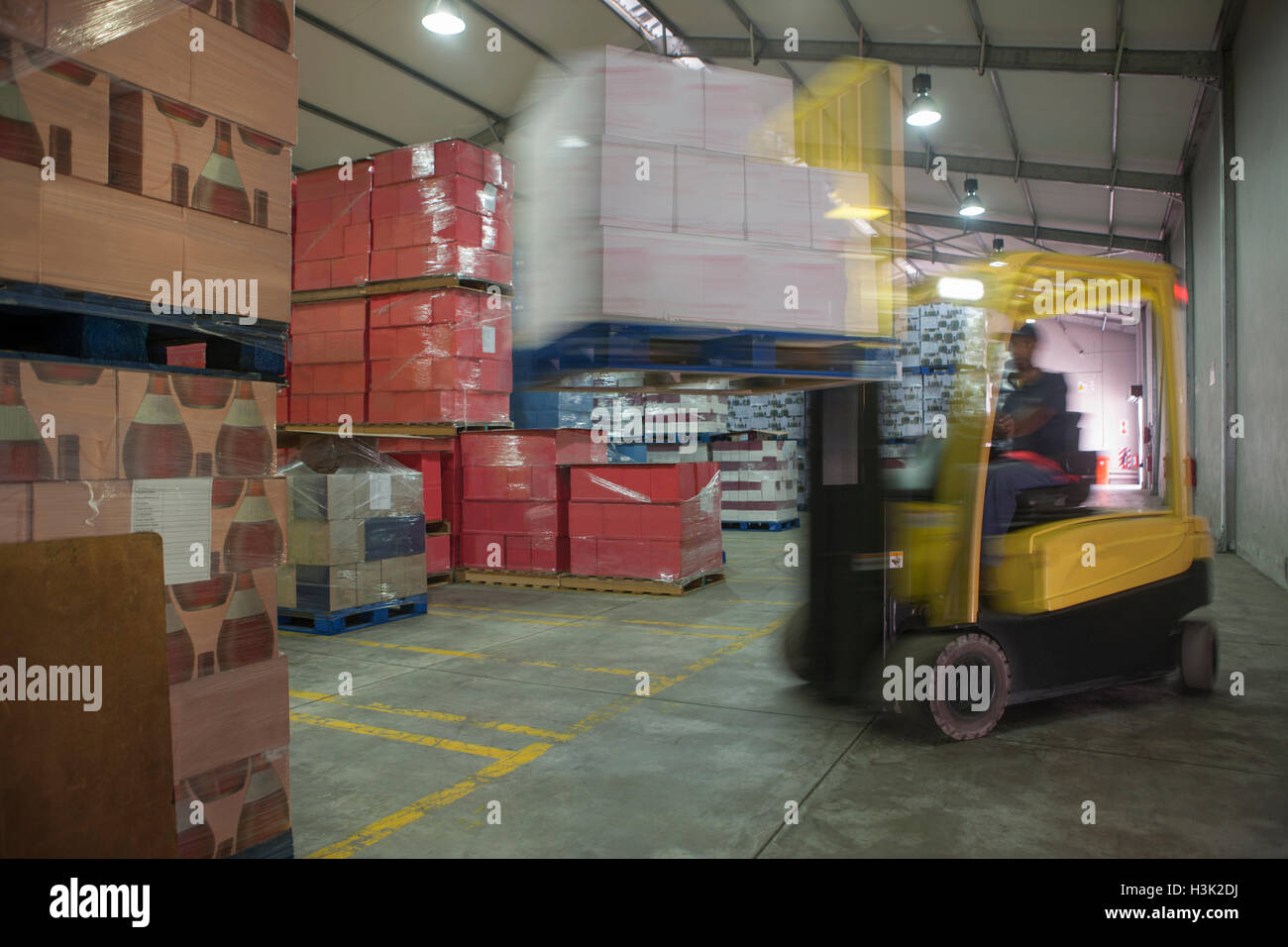 Forklift truck drivers loading pallet at packaging factory warehouse ...