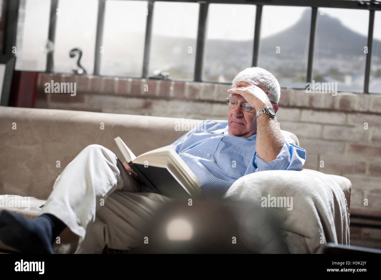 Man reading book at home Stock Photo - Alamy