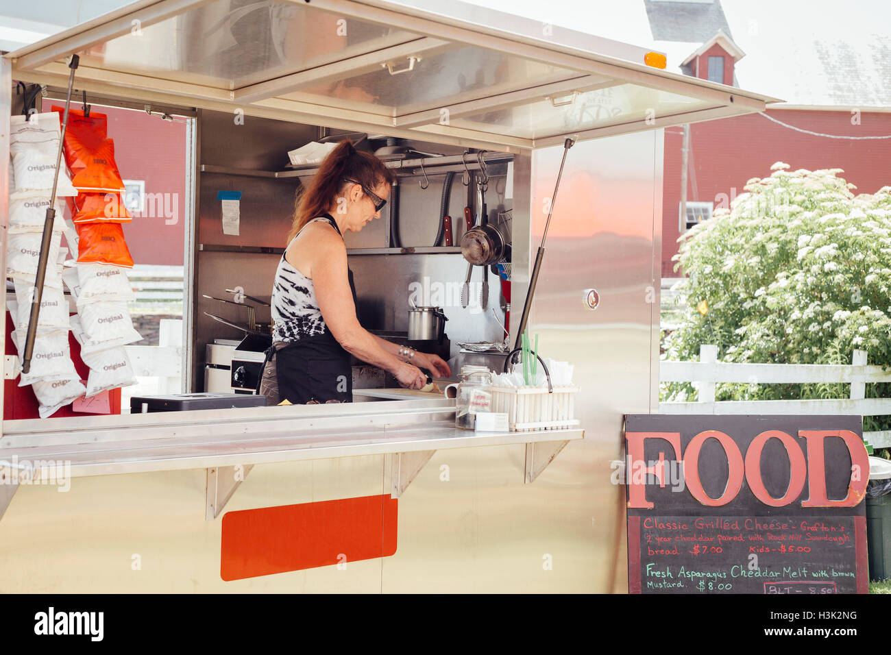 Woman preparing food in kitchen of food stall trailer Stock Photo - Alamy