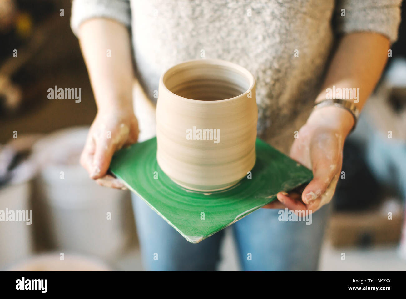 Artist carrying unfinished pottery vase Stock Photo - Alamy