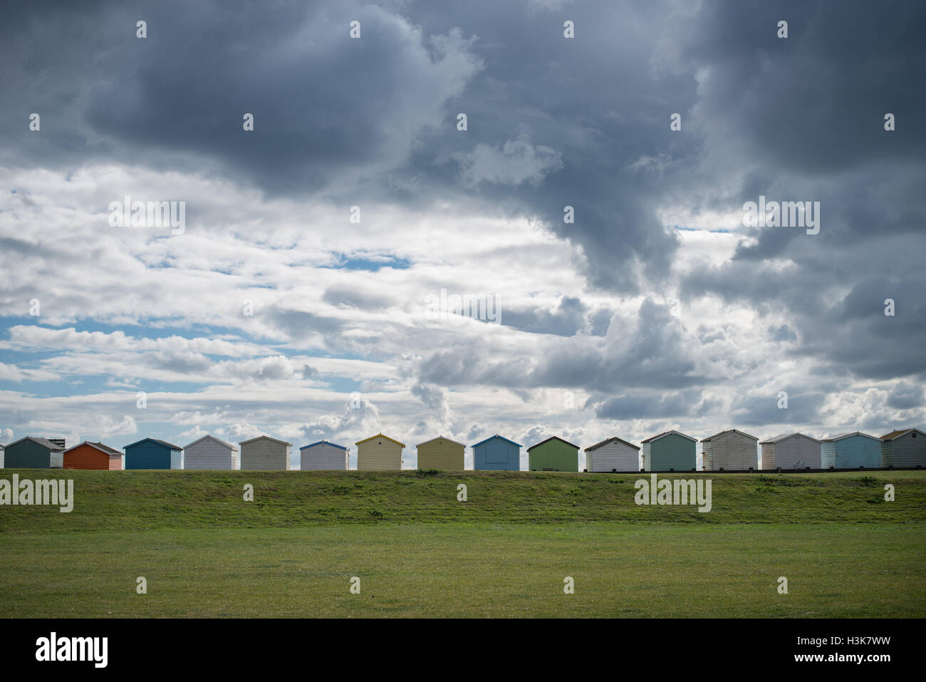 A dramatic sky full of clouds above beach huts on the seafront at ...