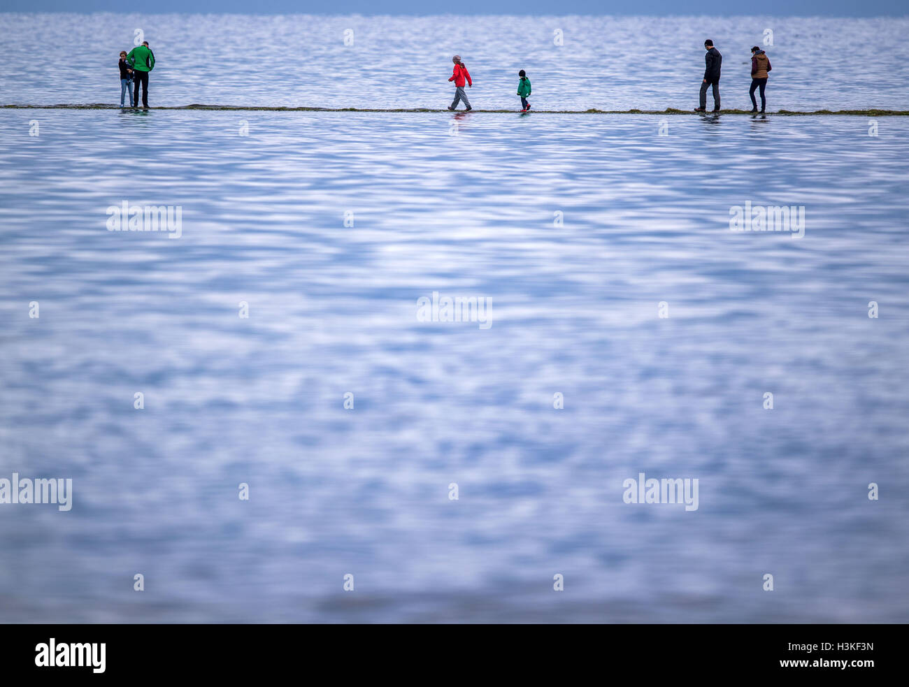 Poel, Germany. 10th Oct, 2016. Holidaymakers walk along a sand bar on ...