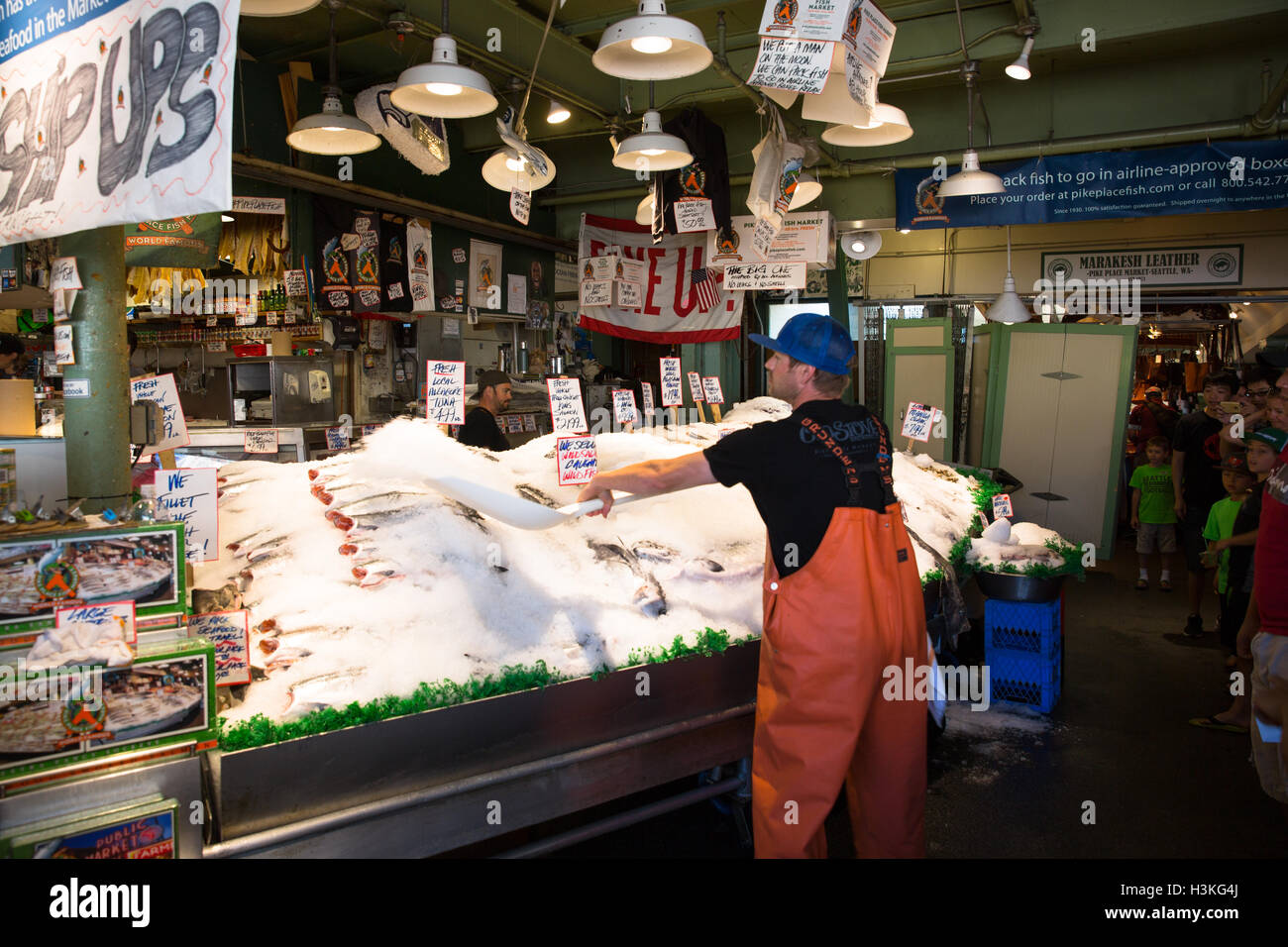 Fish monger throwing ice over fish for sale at Pike Place Fish Market ...