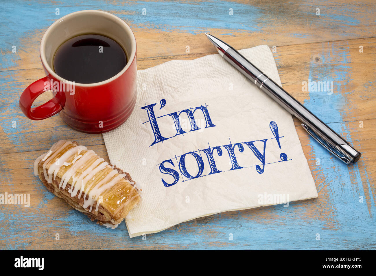 I'm sorry - handwriting on a napkin with a pen,cup of espresso coffee ...