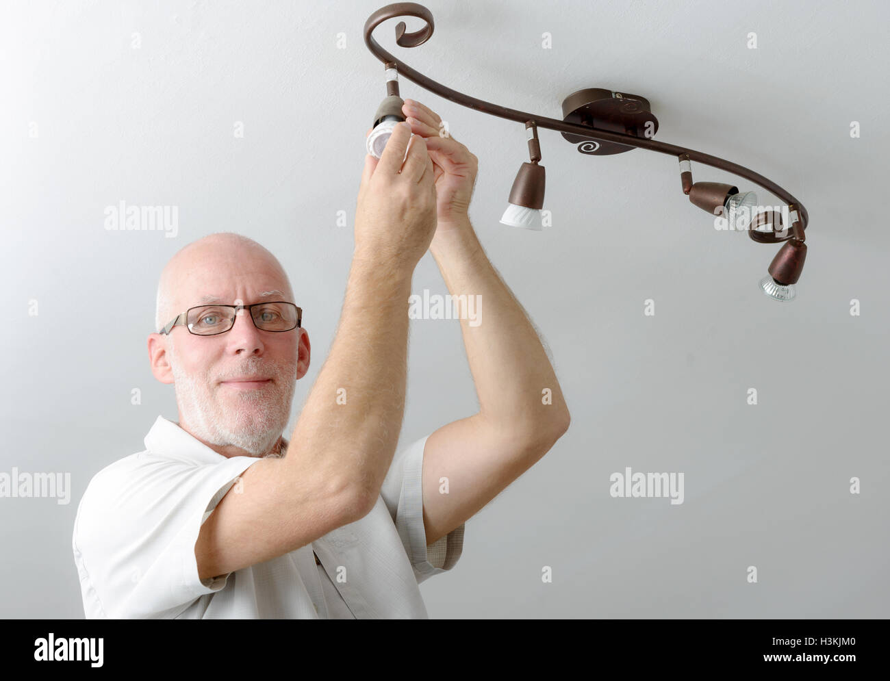 a mature man replacing the light bulb at home Stock Photo - Alamy