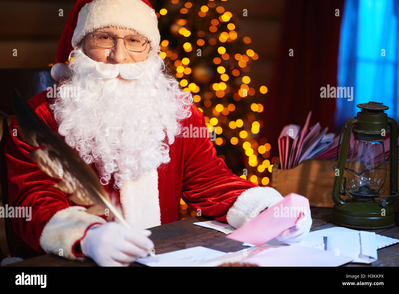 Santa Claus sitting at the table and writing letters Stock Photo - Alamy