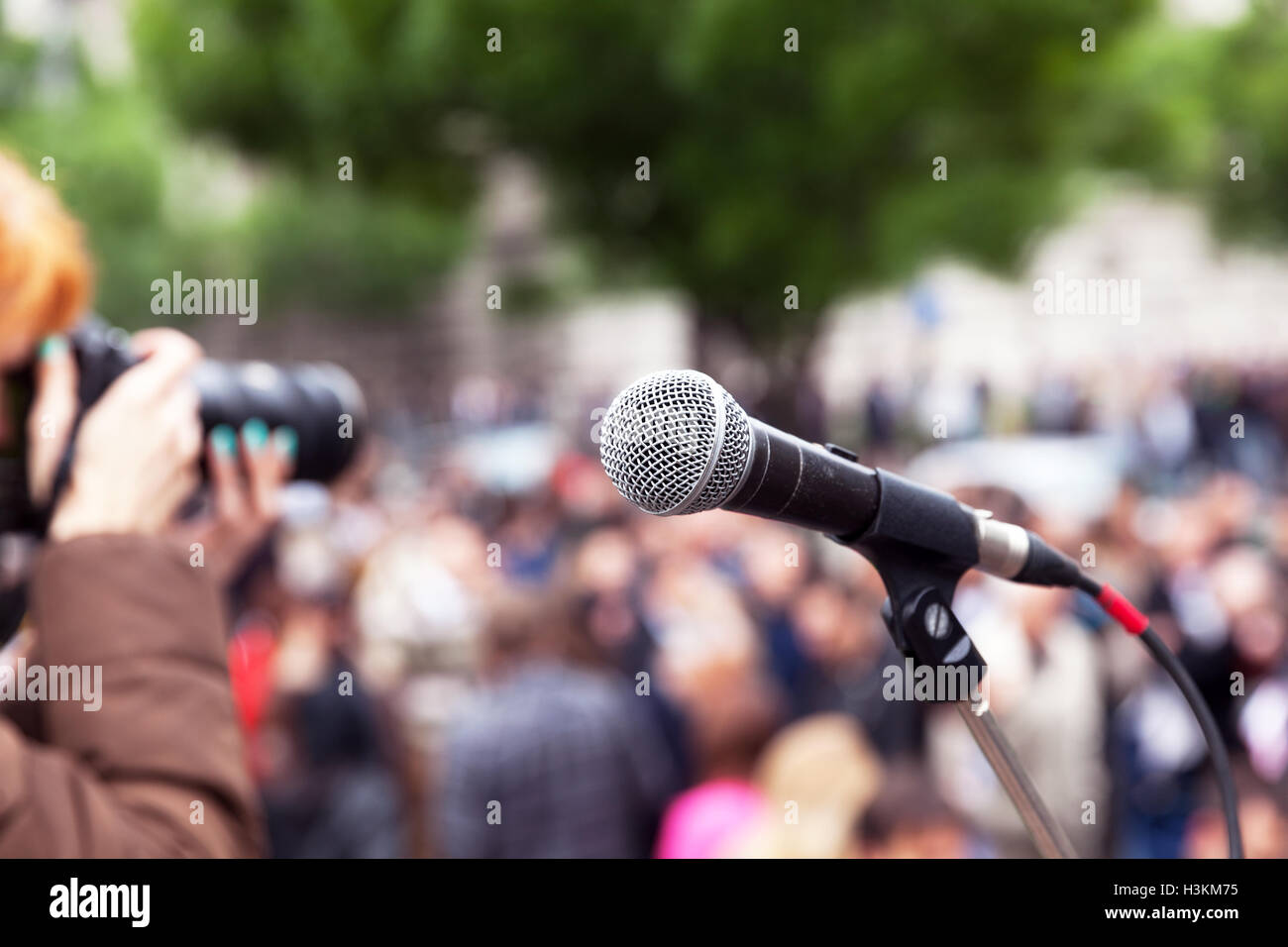 Microphone in focus against blurred crowd. Protest. Public ...