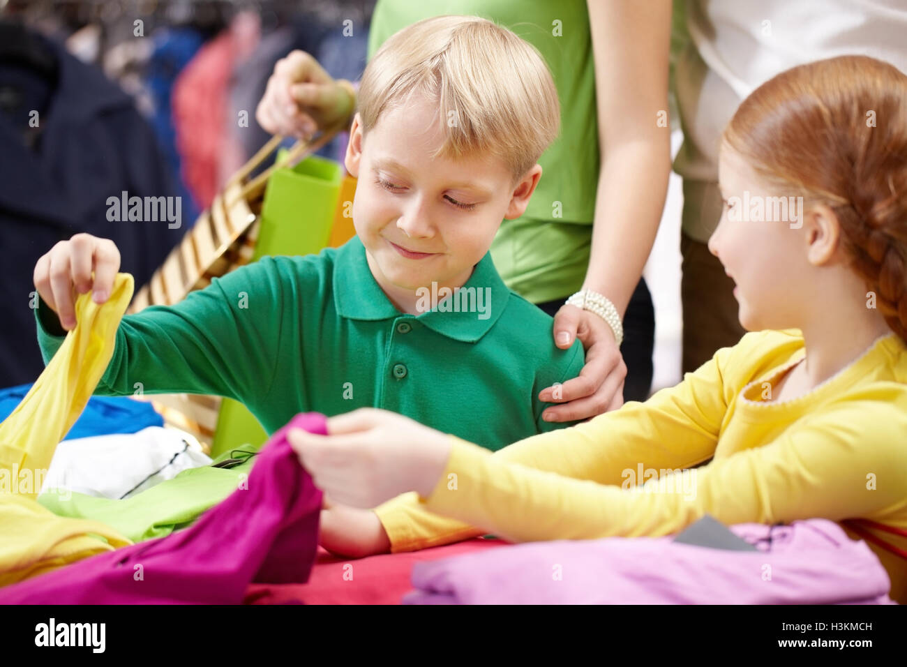 Two little child choosing clothing in the shop Stock Photo - Alamy