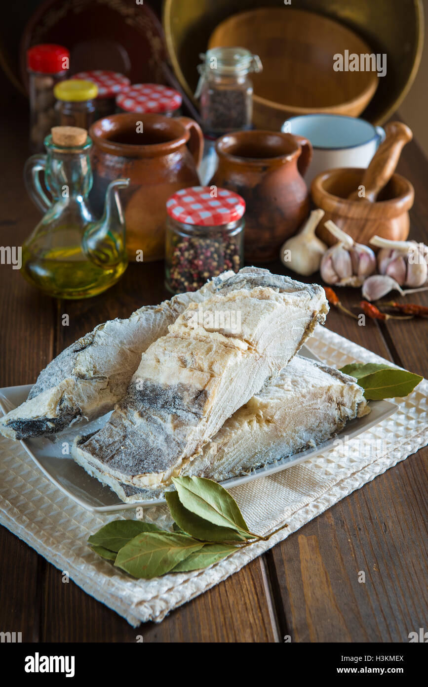 Salted cod cut with ingredients and utensils on the table of the ...