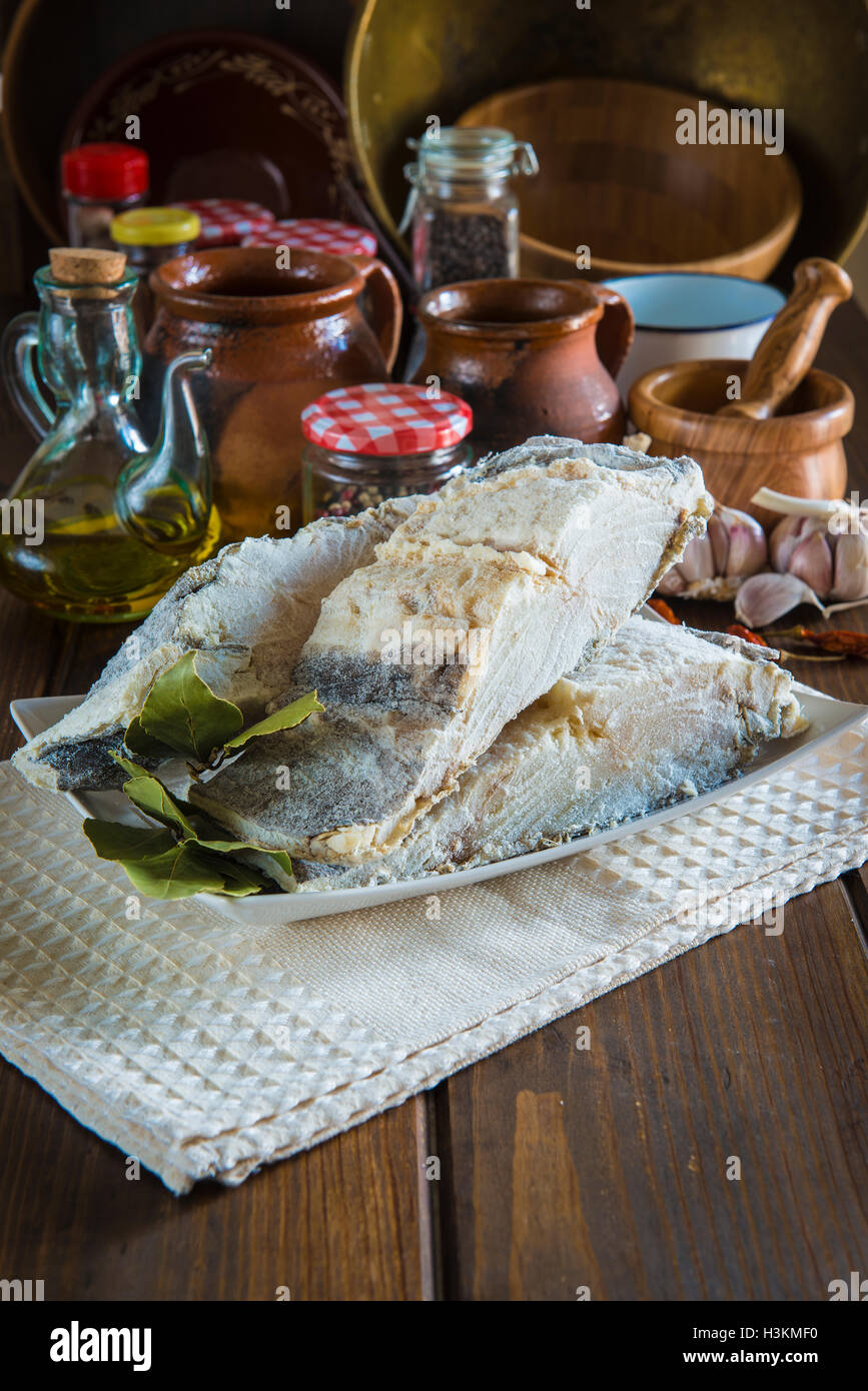 Salted cod cut with ingredients and utensils on the table of the ...