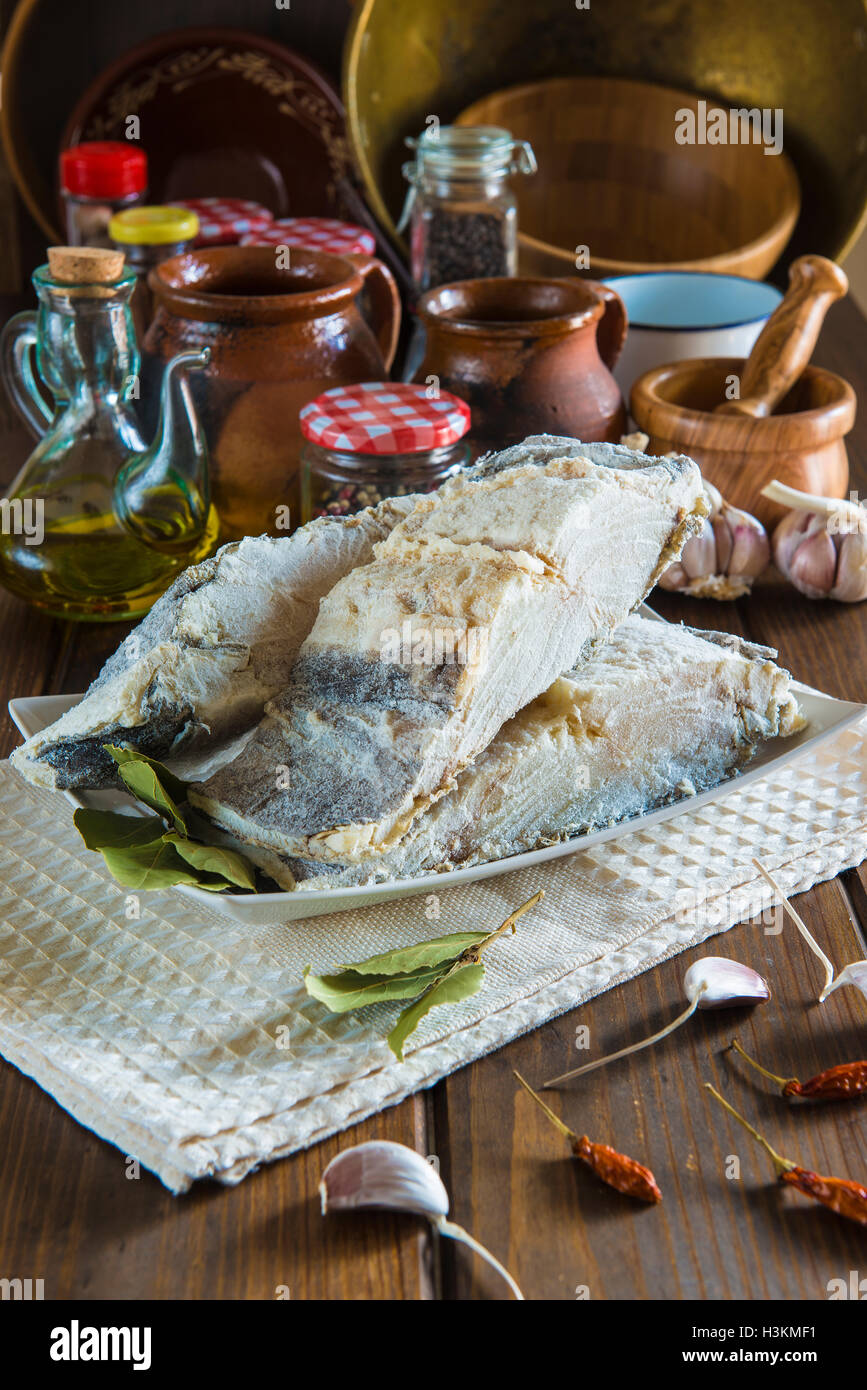 Salted cod cut with ingredients and utensils on the table of the ...