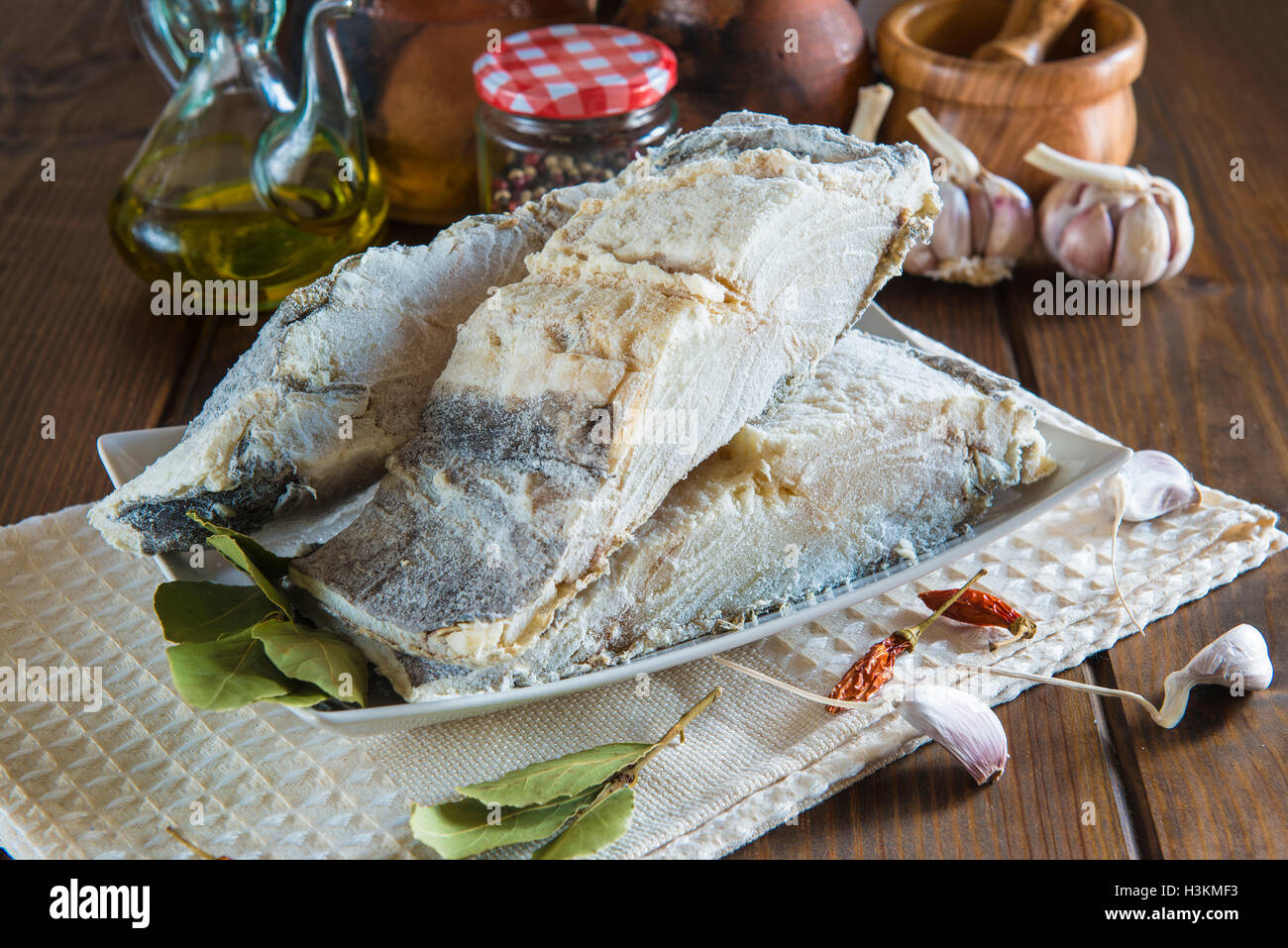 Salted cod cut with ingredients and utensils on the table of the ...