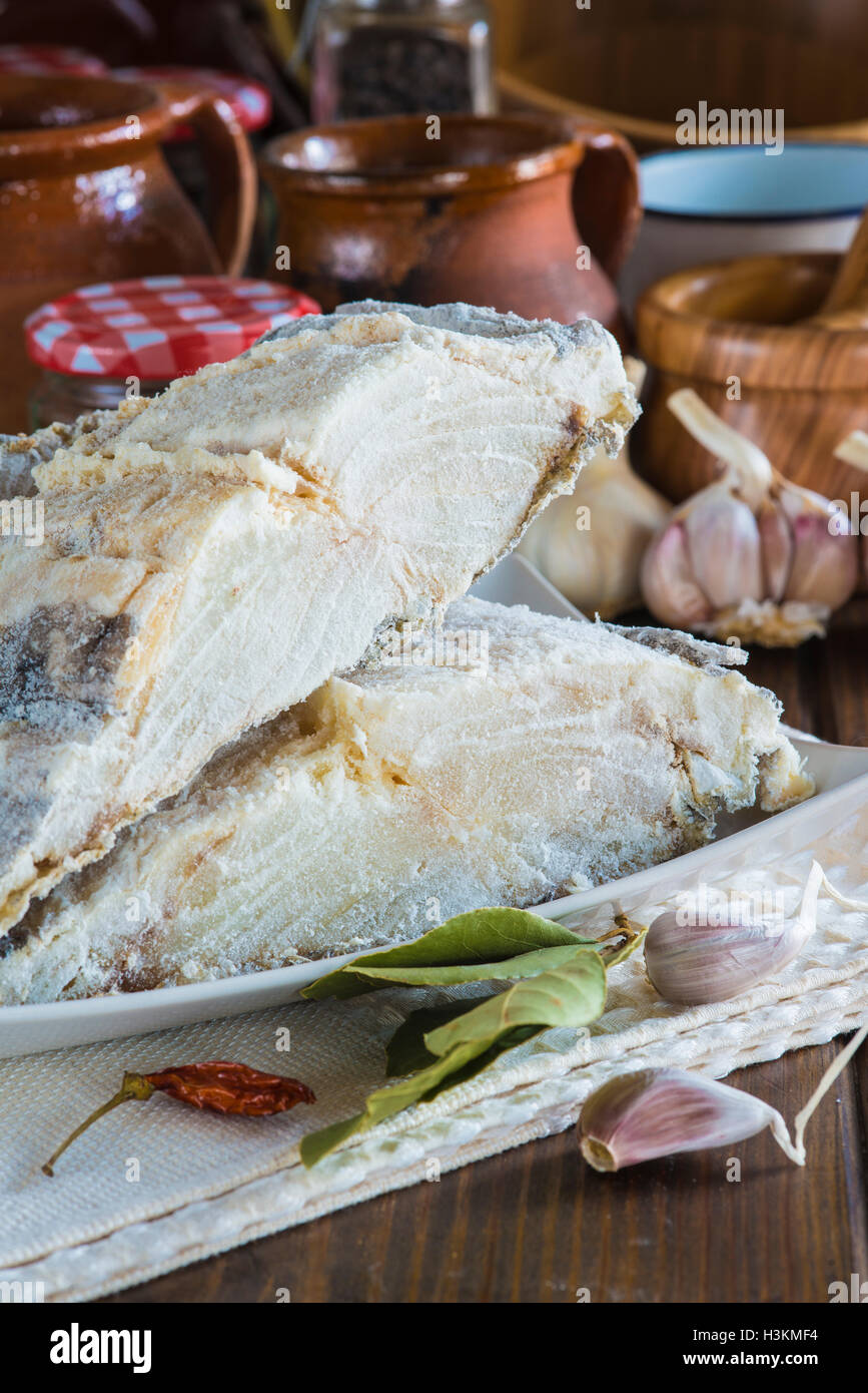 Salted cod cut with ingredients and utensils on the table of the ...