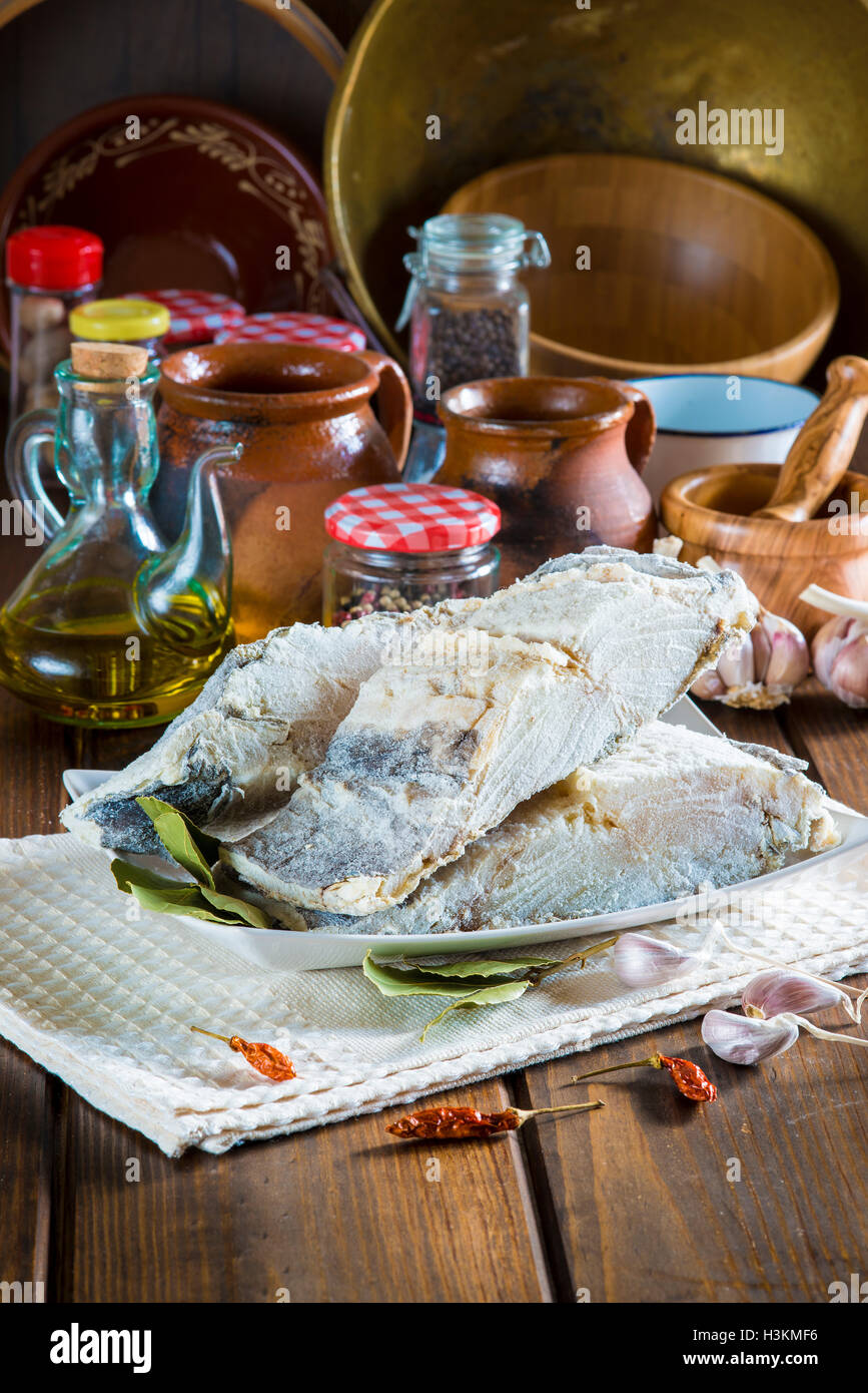 Salted cod cut with ingredients and utensils on the table of the ...