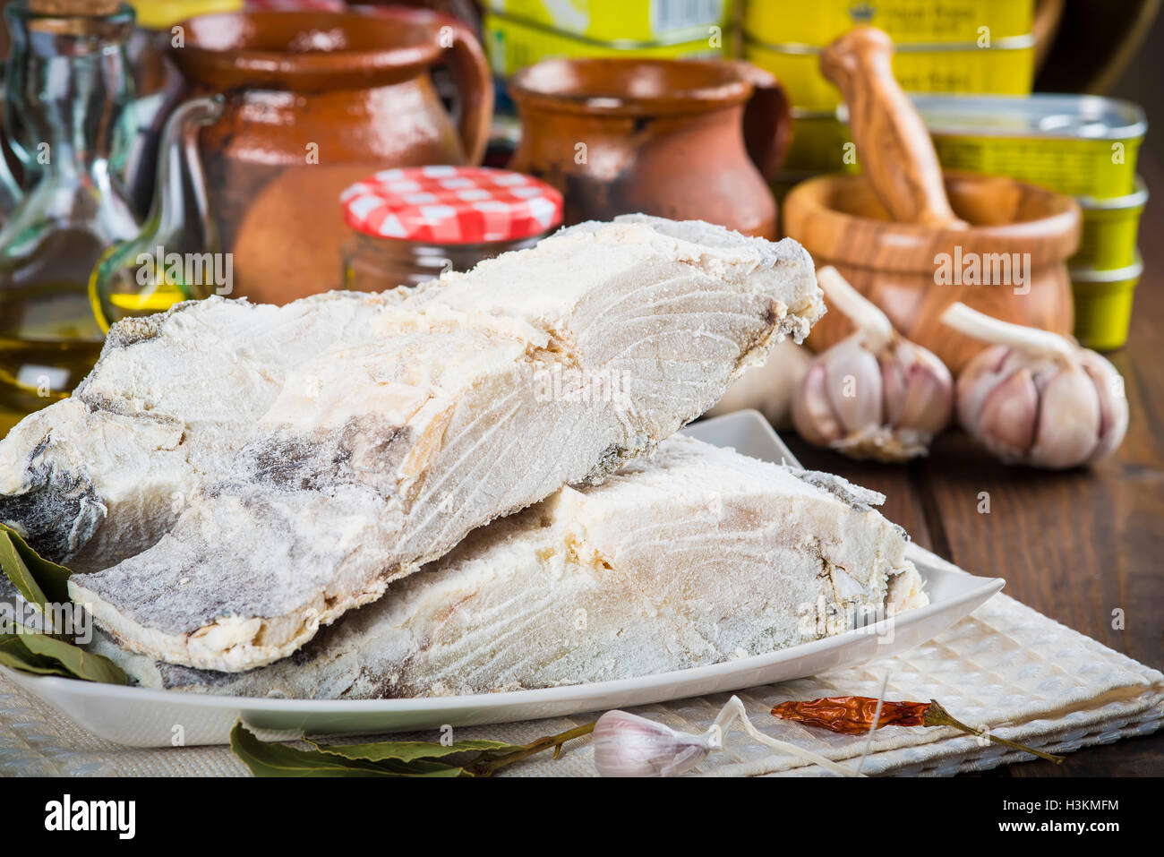 Salted cod cut with ingredients and utensils on the table of the ...