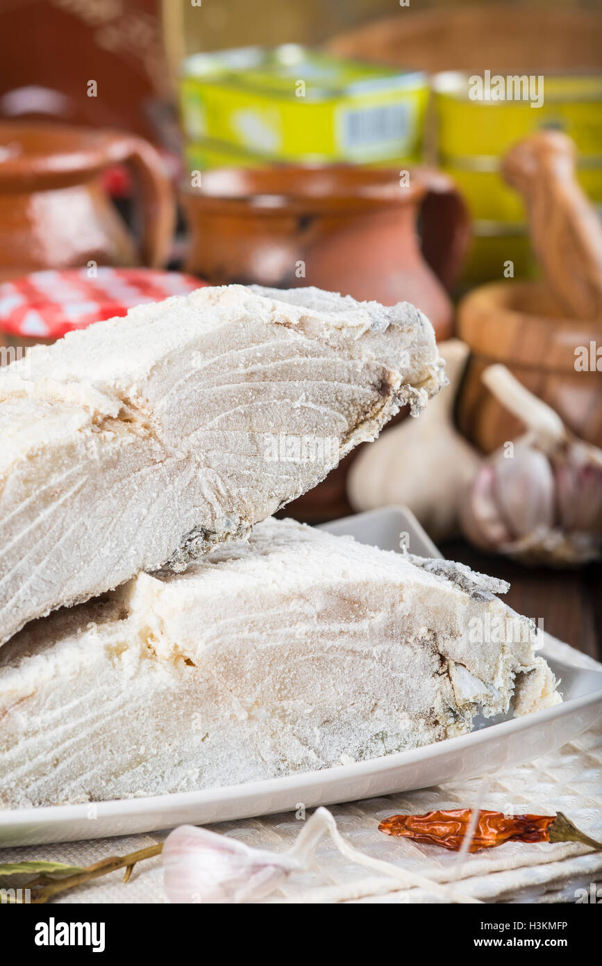 Salted cod cut with ingredients and utensils on the table of the ...
