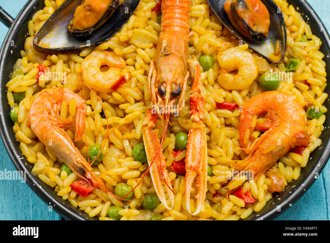 Spanish paella on a blue wooden table Stock Photo - Alamy