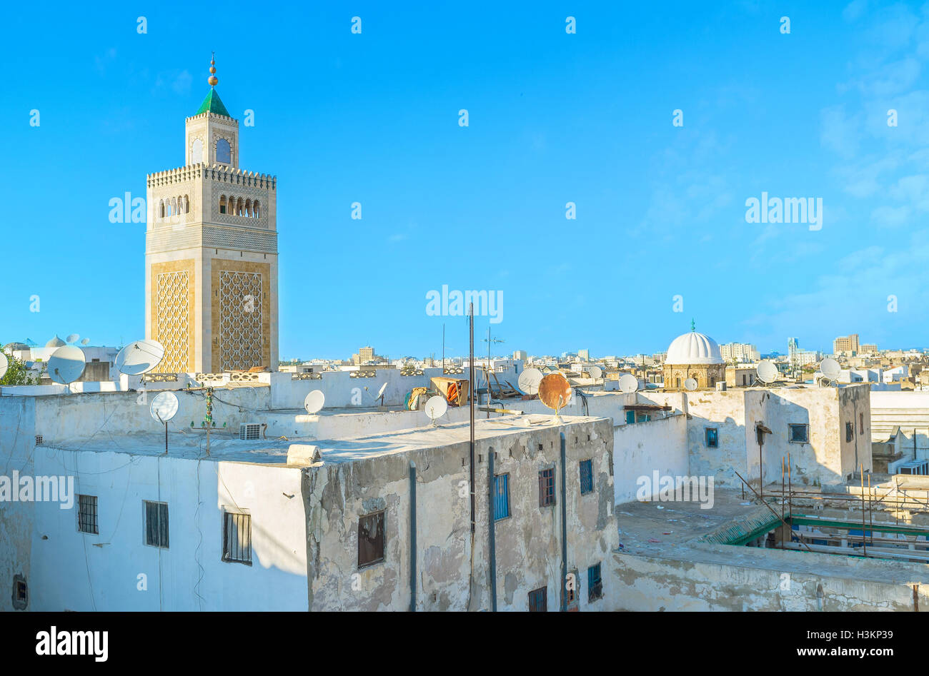 The high minaret of the Great Mosque rises over the white roofs of ...