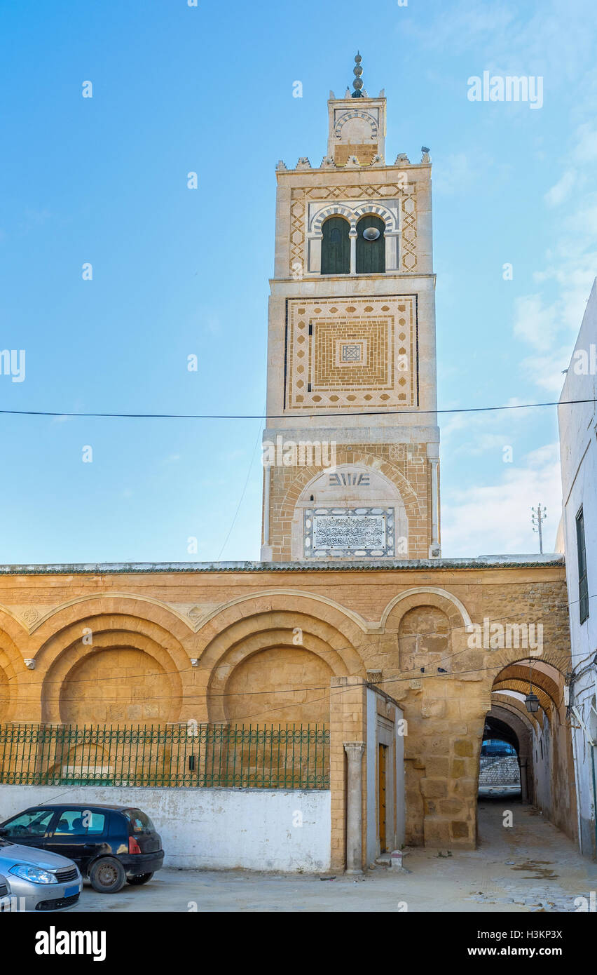 The medieval mosque with the arched wall and high rectangular minaret ...