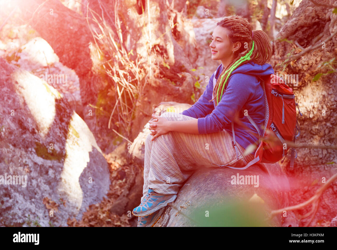 Cute Girl sitting on Tree Stalk Forest enjoying warm Sunshine Stock ...