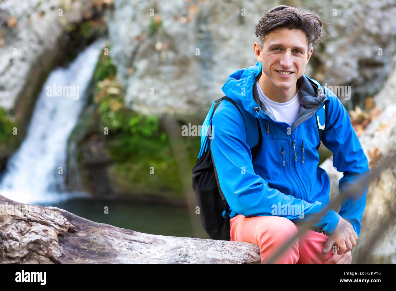 Portrait of handsome male Hiker sitting tree trench at lake Stock Photo ...