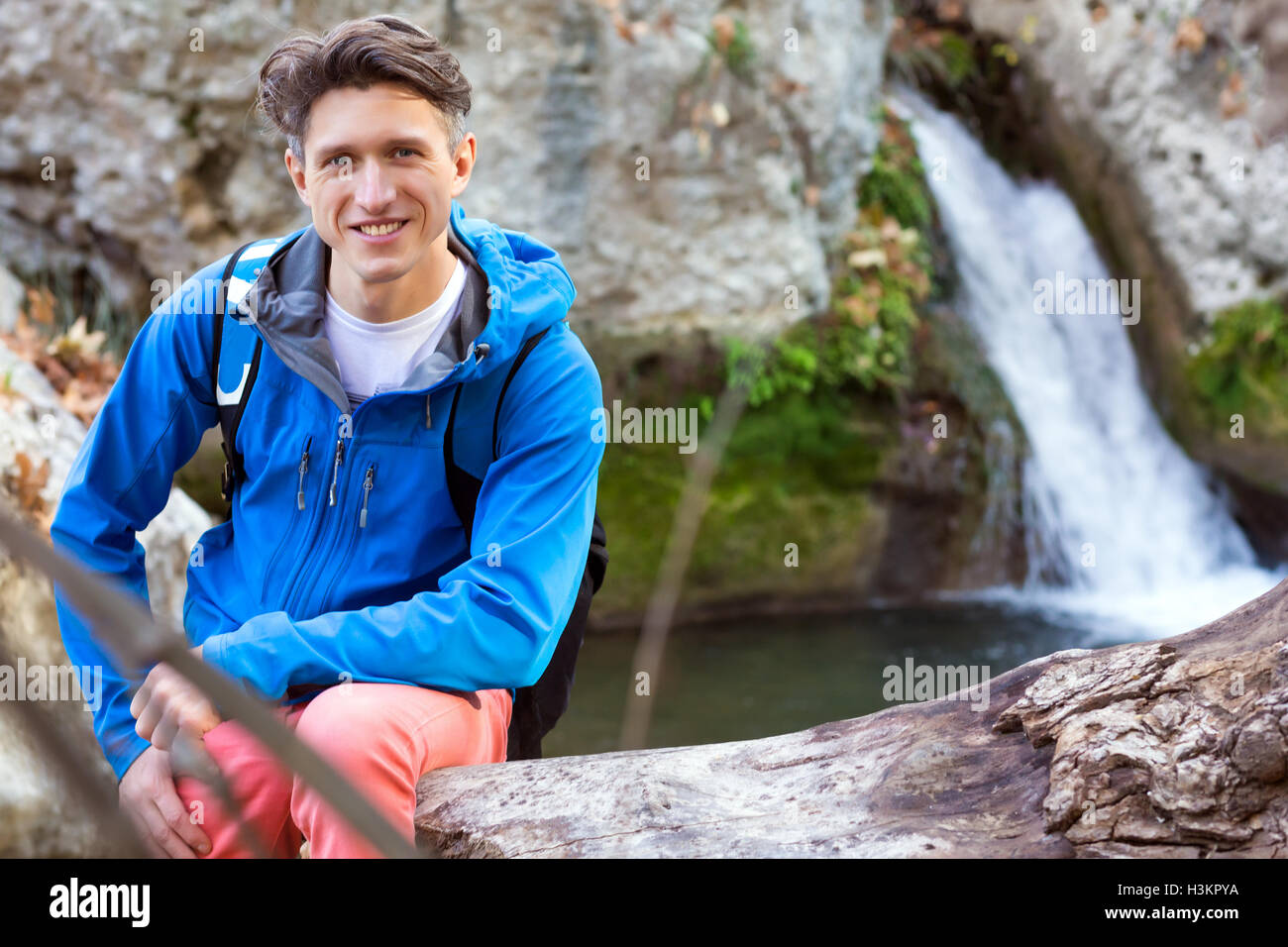 Portrait of handsome male Hiker sitting tree trench at lake Stock Photo ...