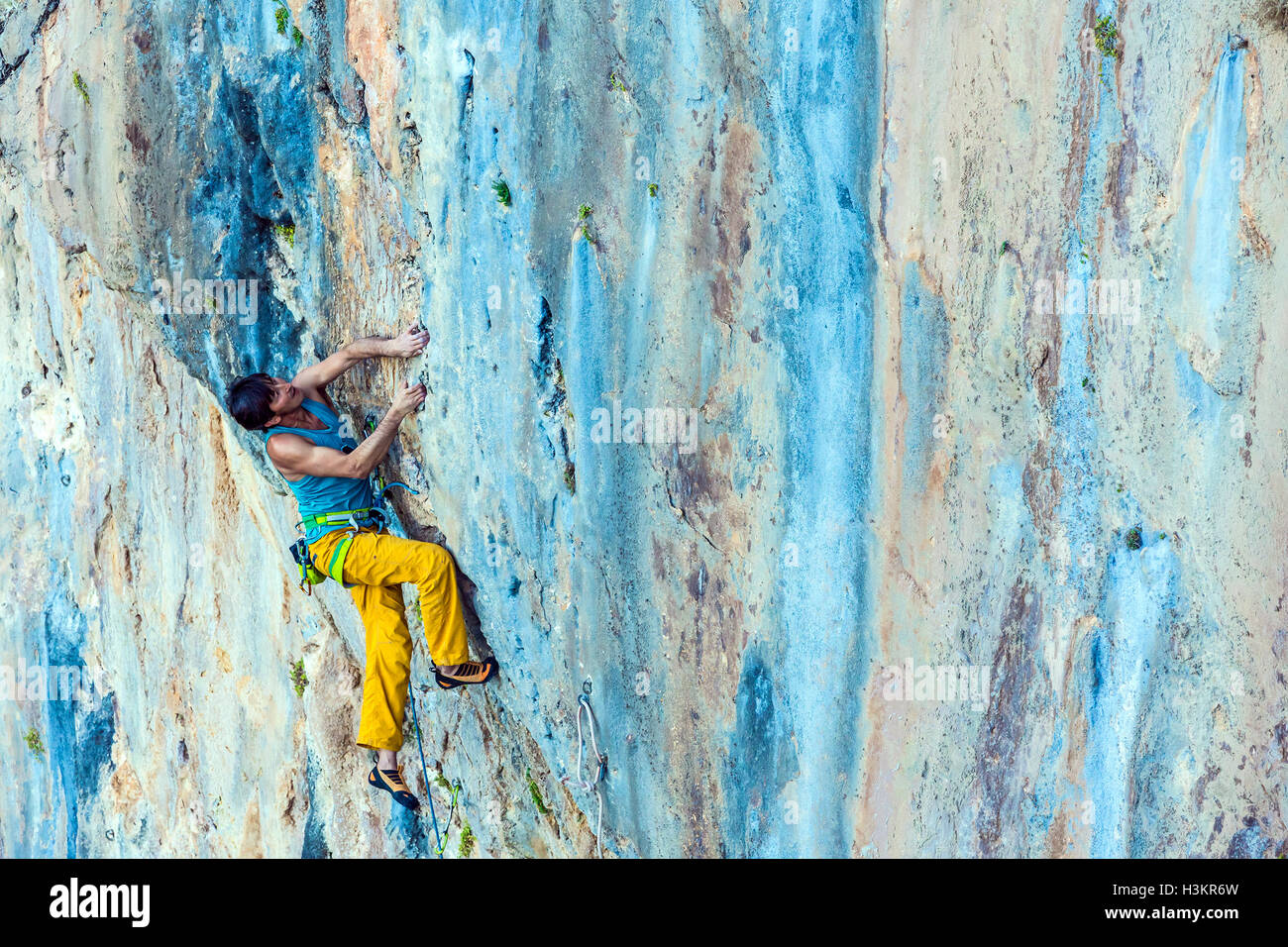 Side View of Male Climber hanging on vertical Rock Stock Photo - Alamy