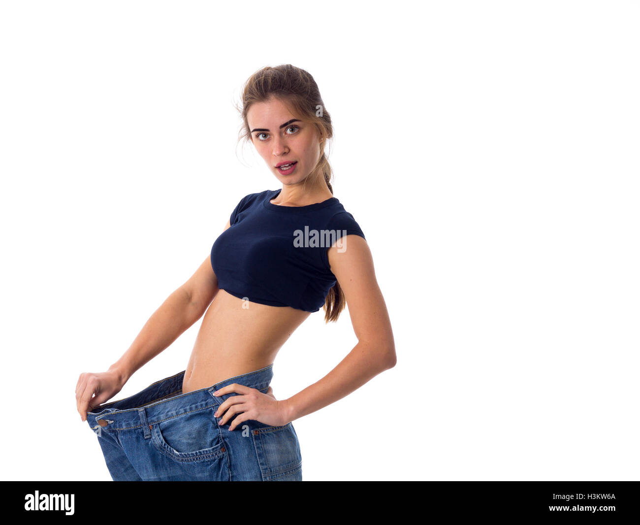 Woman wearing jeans of much bigger size Stock Photo - Alamy