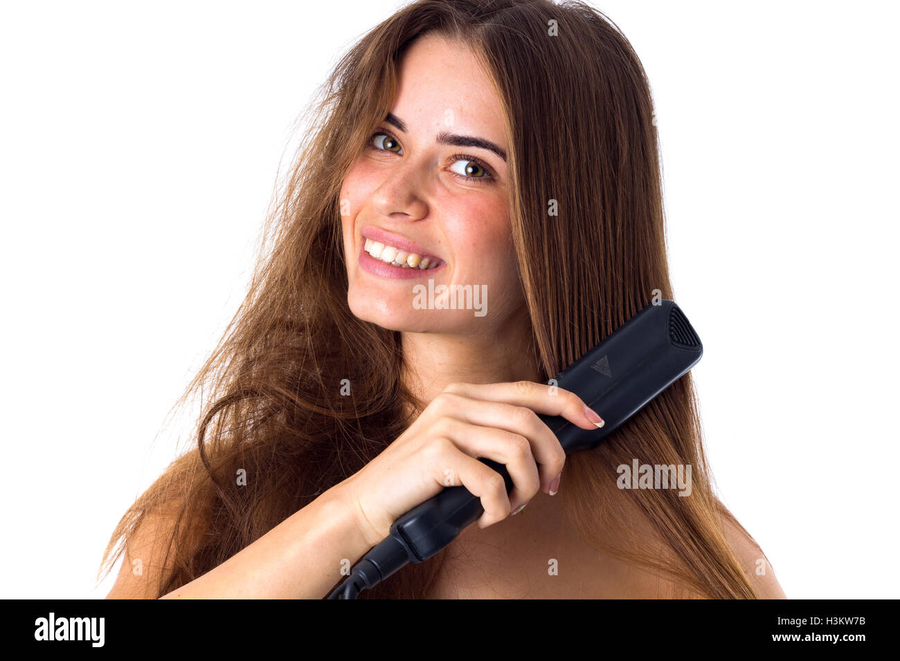 Woman using hair straightener Stock Photo - Alamy