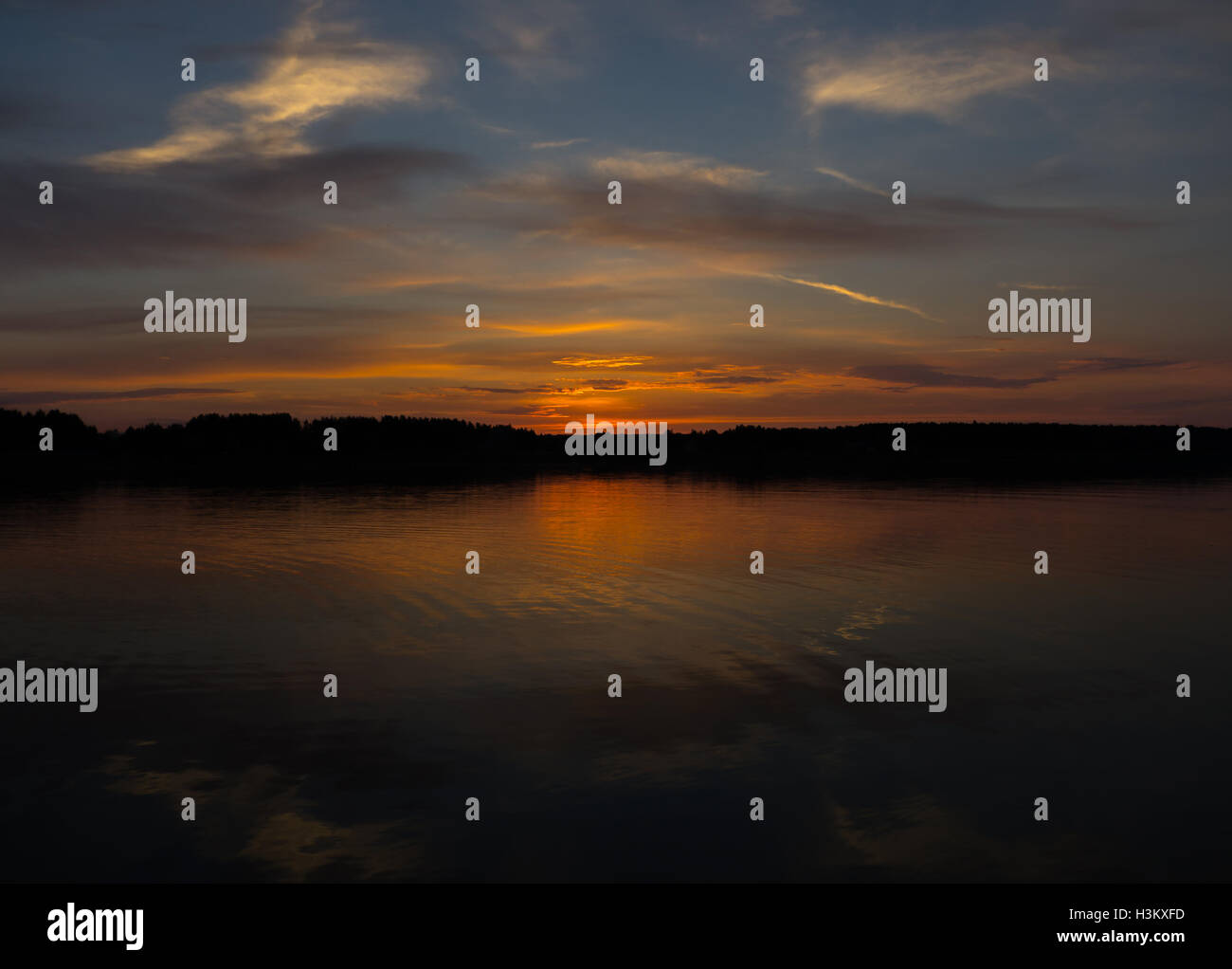 Majestic red sunset on the river bank and its reflection in water Stock ...