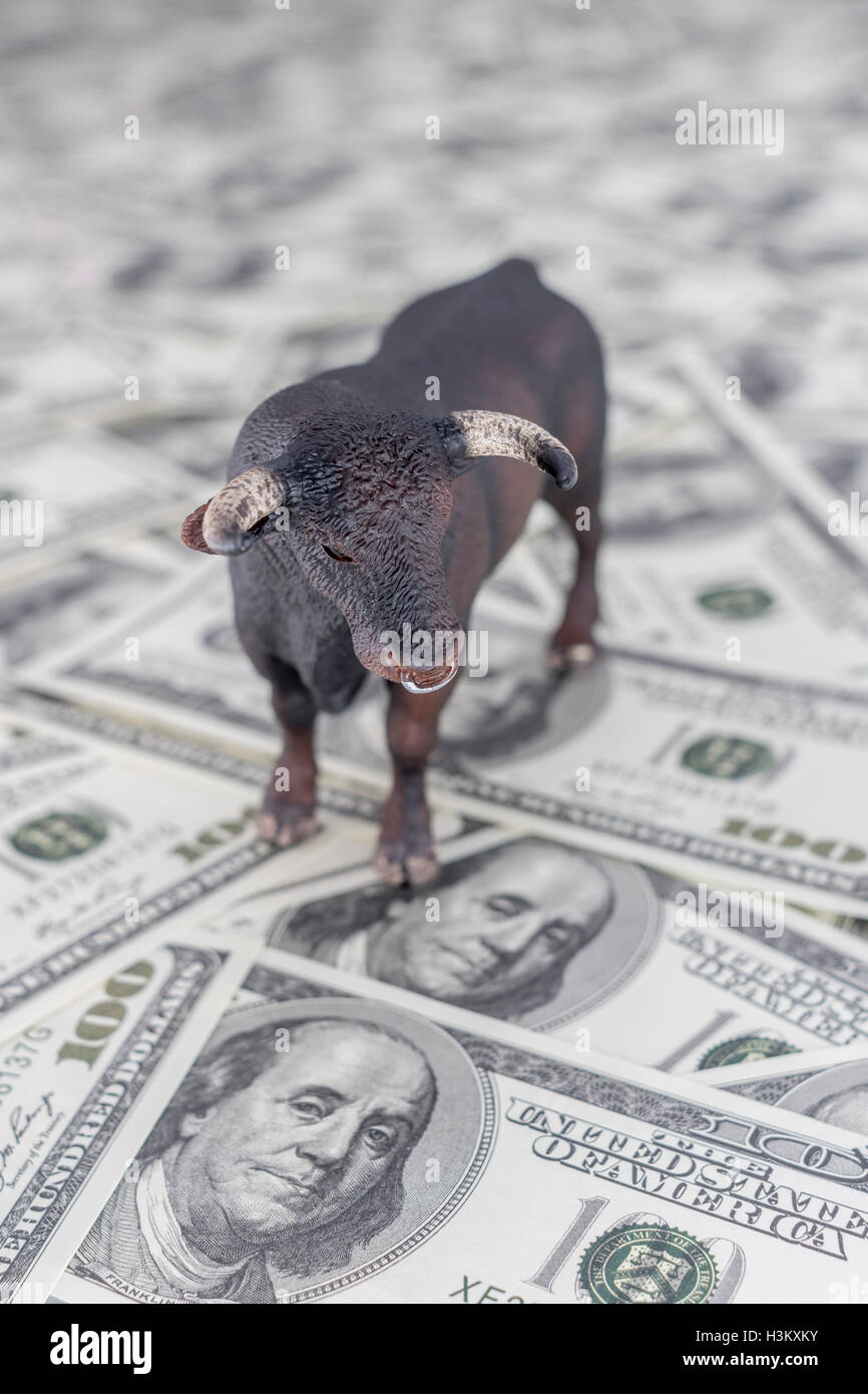 Bull with pile / stash of US 100$ Franklin bills / banknotes, as visual ...