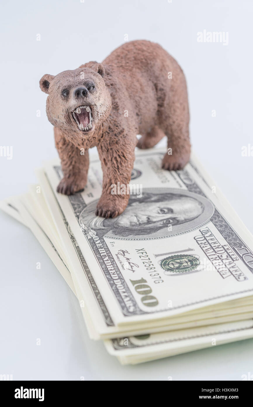 Bear with pile of US 100$ Franklin bills / banknotes, as metaphor for ...