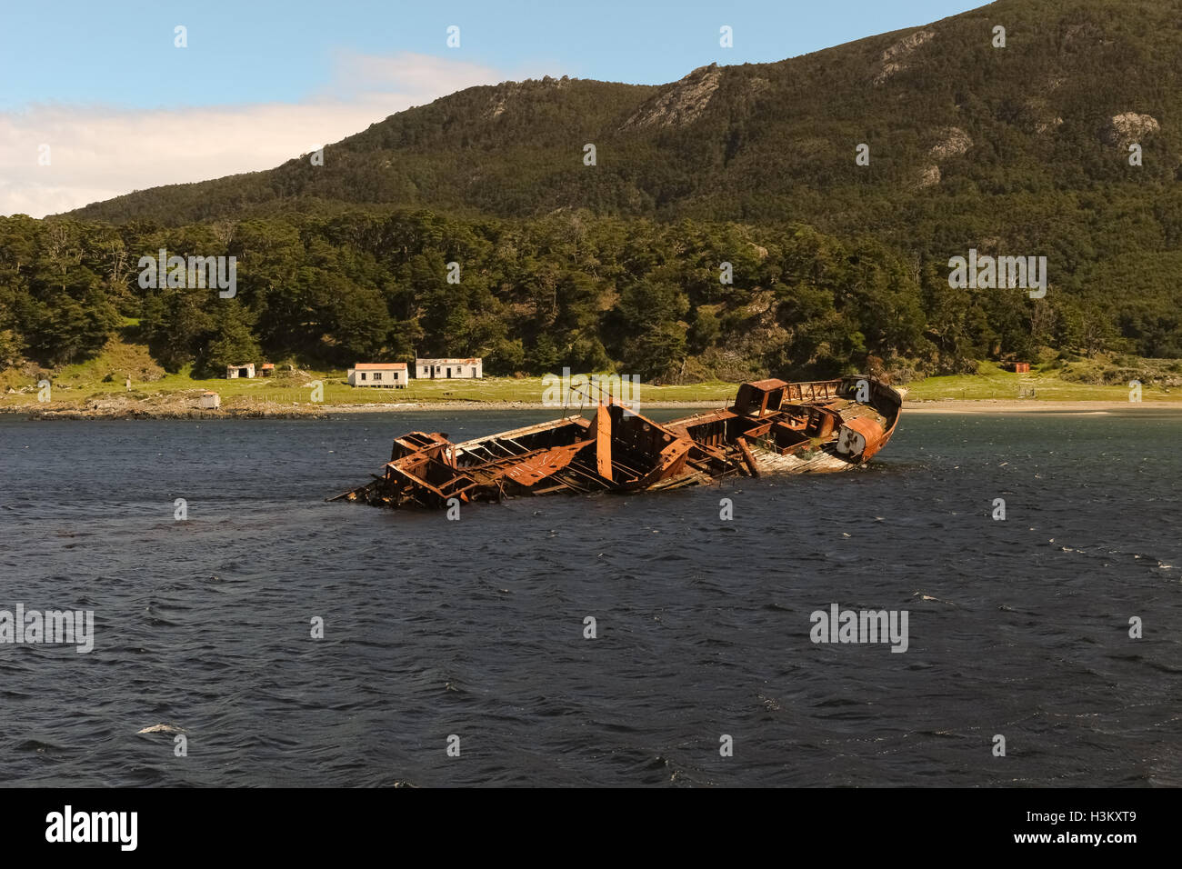 Rusty ship wreck sunk in the dark blue waters of the Beagle channel ...