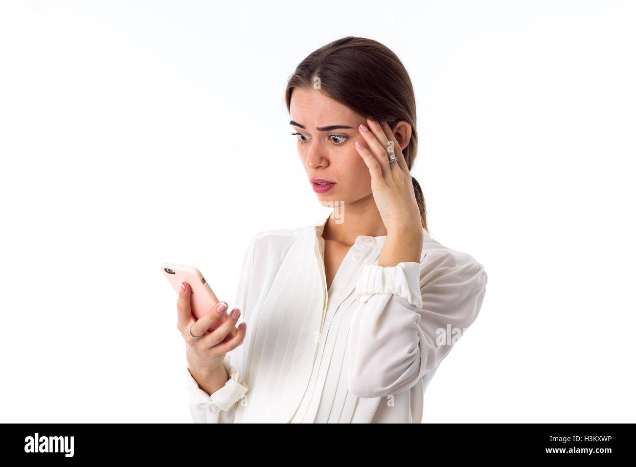 Woman looking scaredly on her phone Stock Photo - Alamy