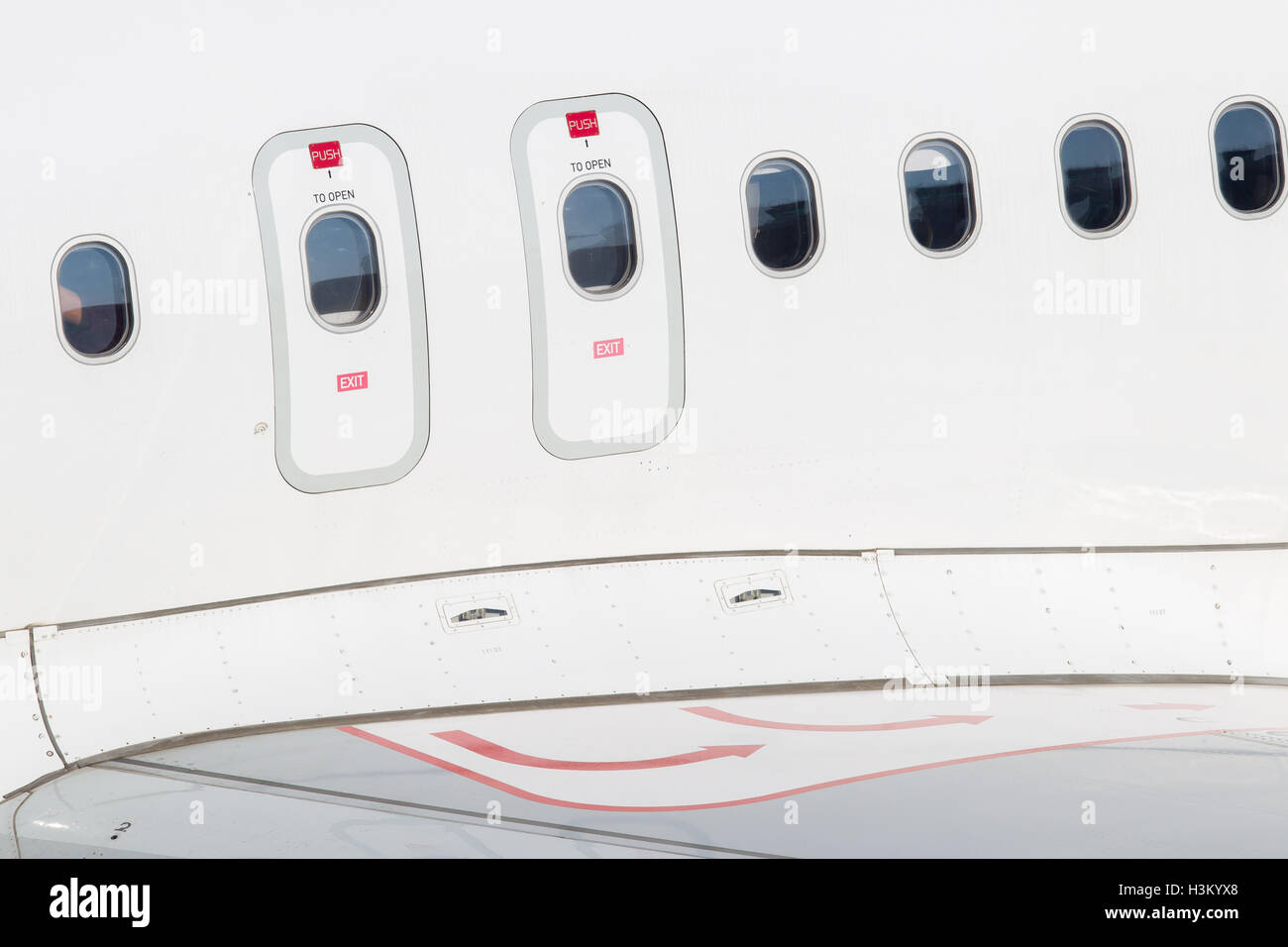 Windows of airplane with emergency exit door Stock Photo - Alamy