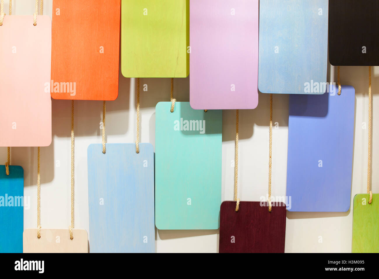 Pieces of wood with different colors hanging on the wall. Horizontal ...