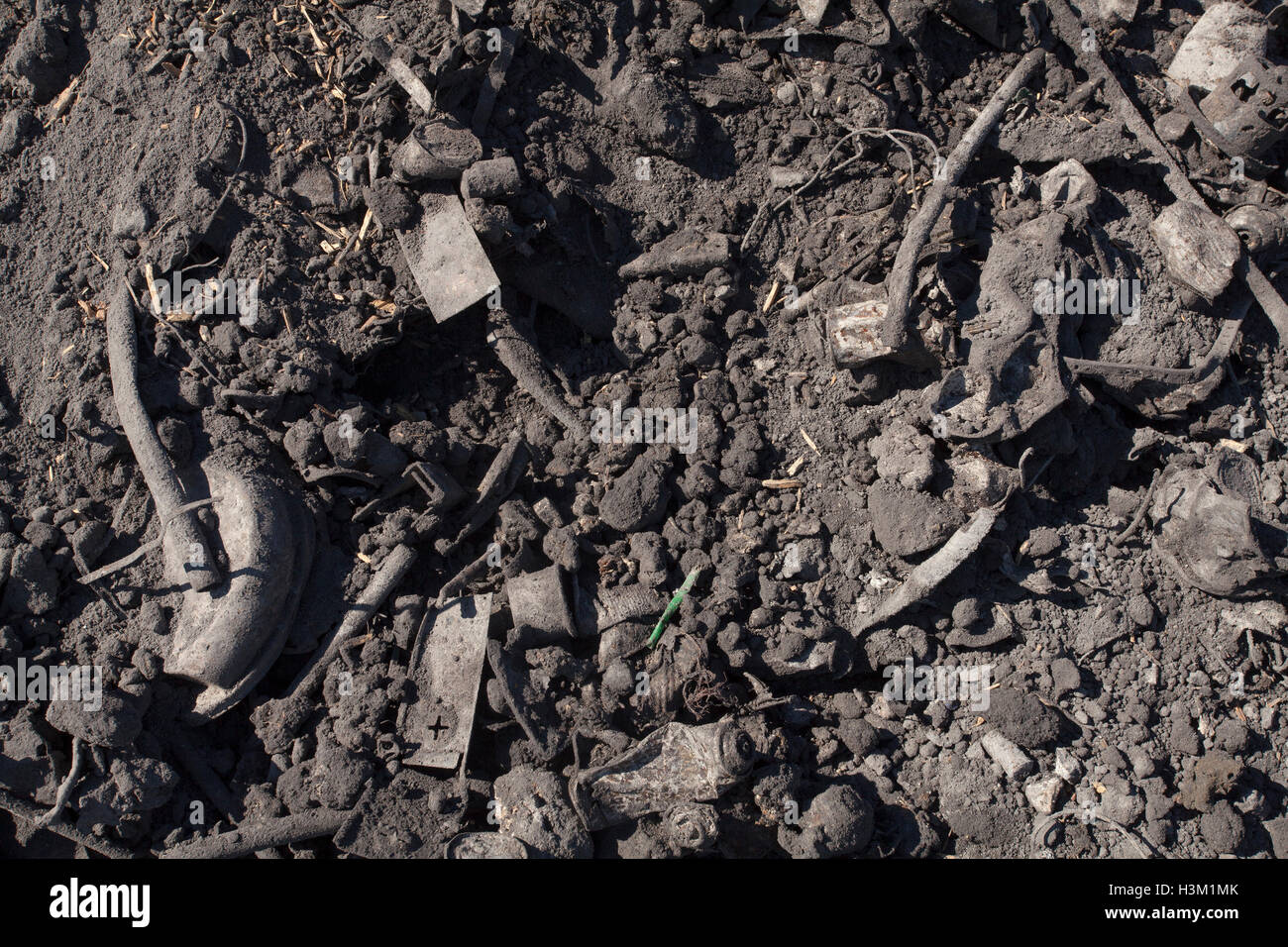 Ash and debris from a heap of burned trash at a municipal landfill site ...