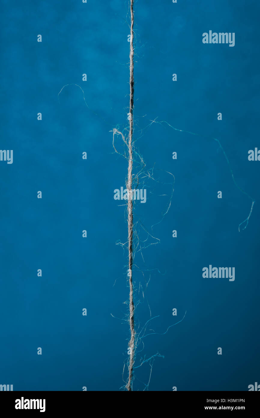 Piece of frayed natural fiber string against a dark background - visual ...