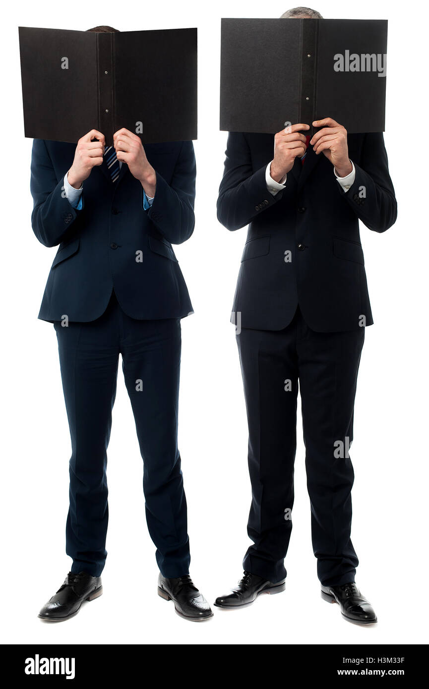 Businessmen hiding their faces with folder Stock Photo - Alamy