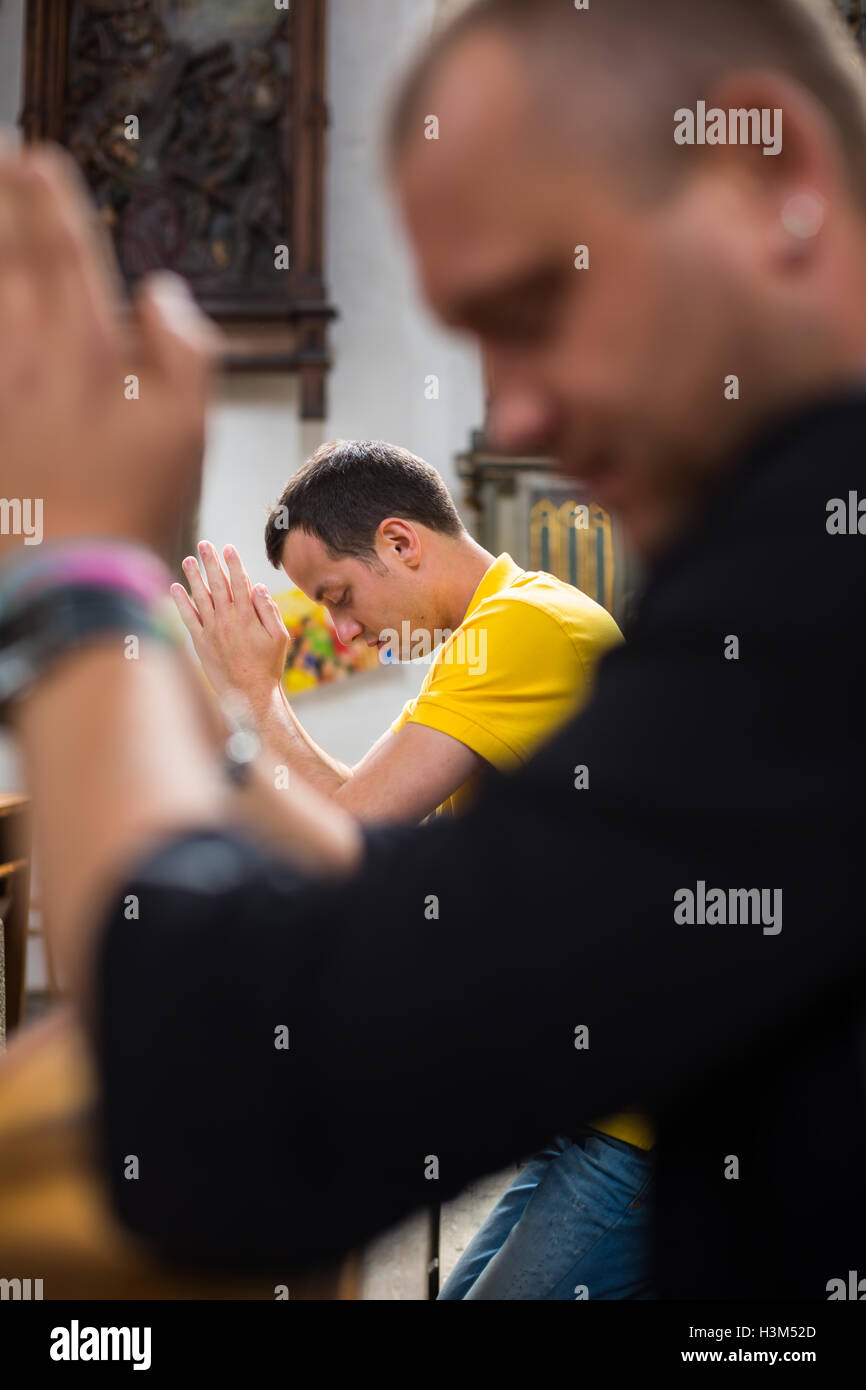Handsome young man praying in a church Stock Photo - Alamy