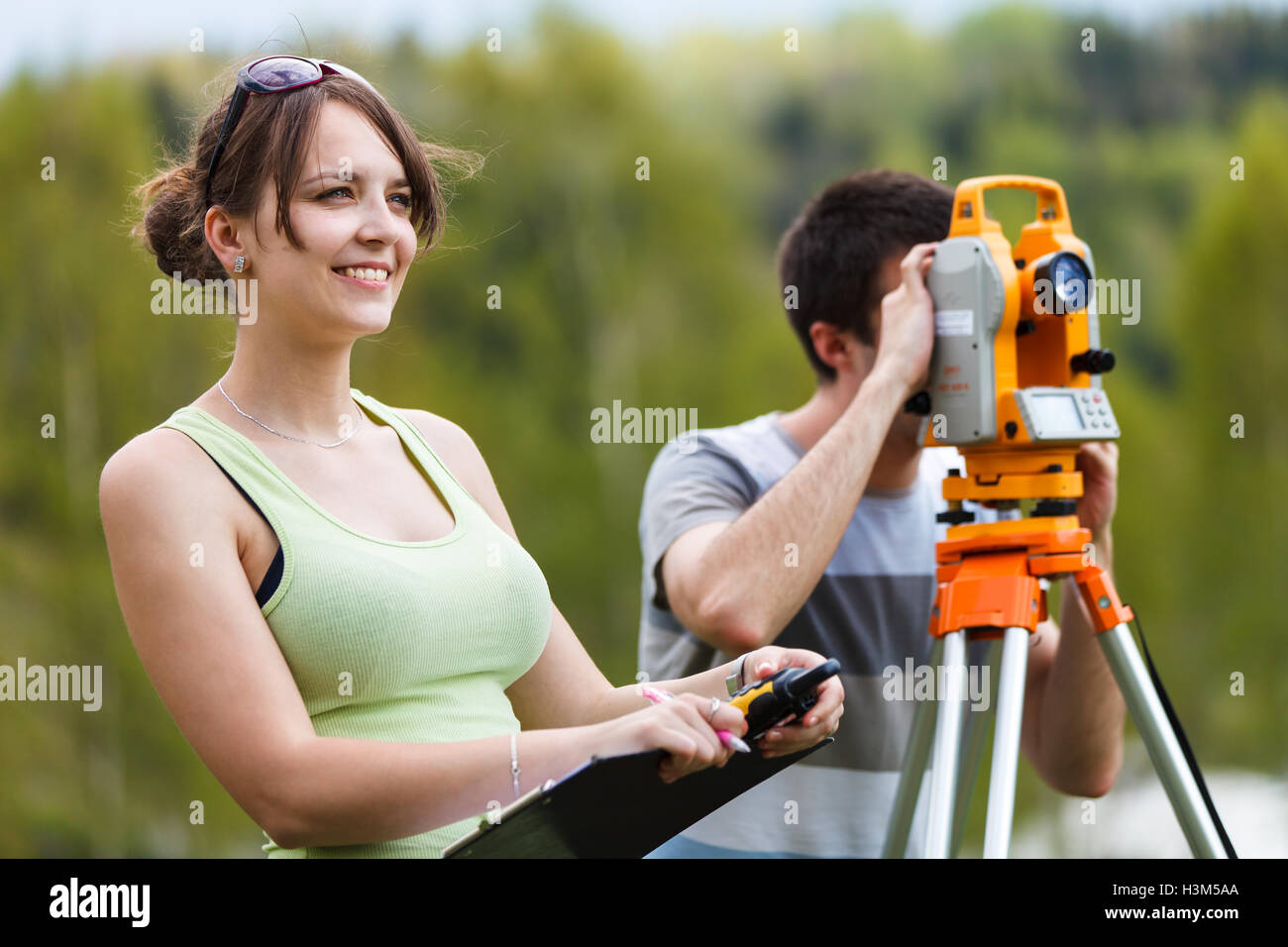 Two young land surveyors at work Stock Photo - Alamy