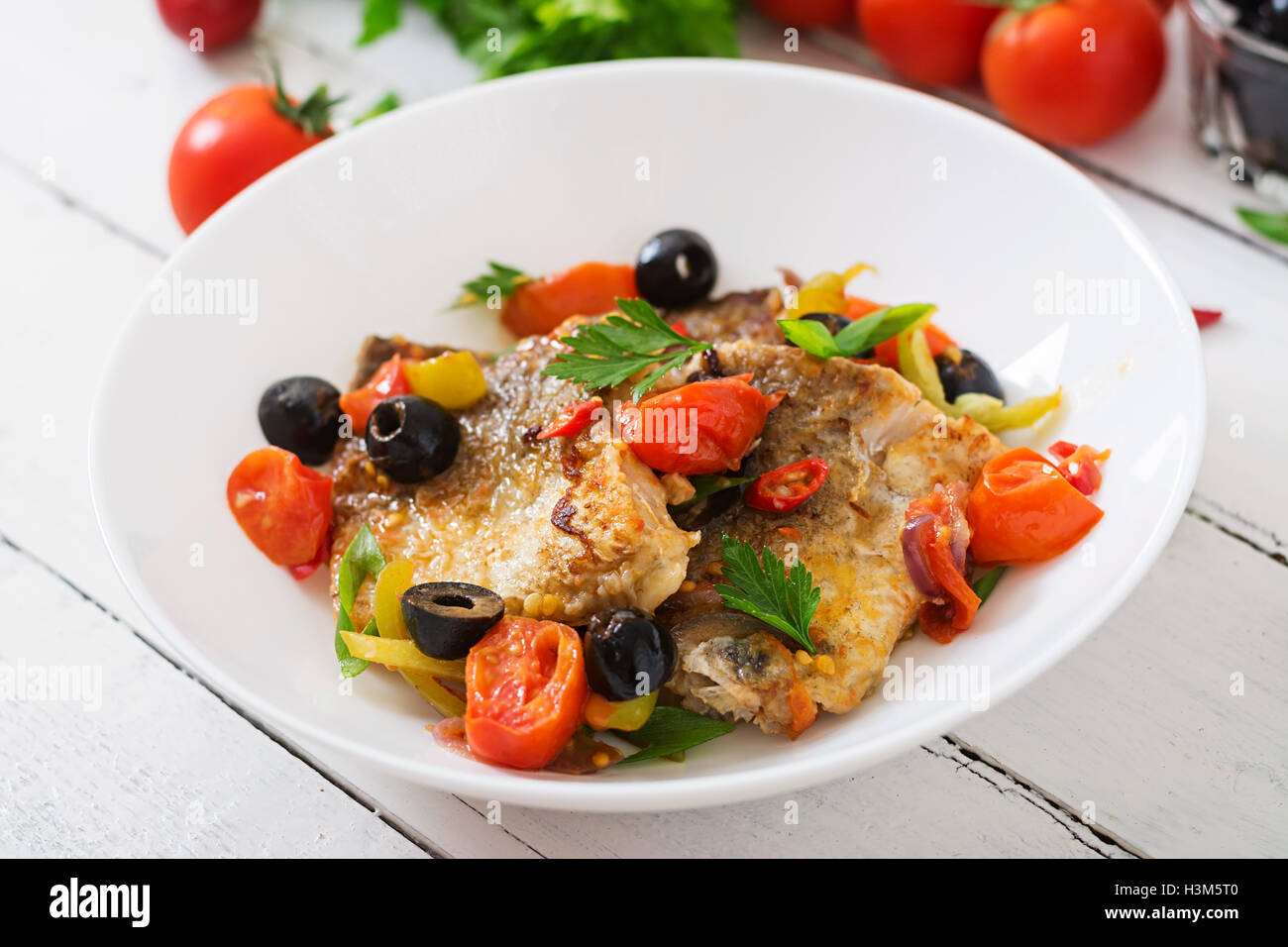 Fried hake fillet with tomato and olives in the Mediterranean style ...