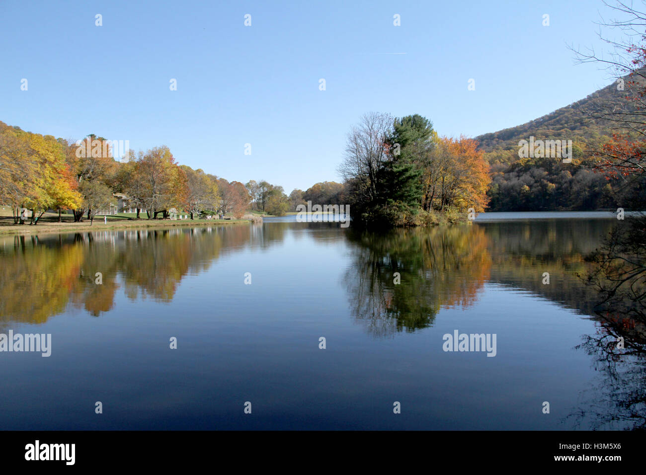Virginia, USA. View of Abbott Lake with trees on island, in autumn ...