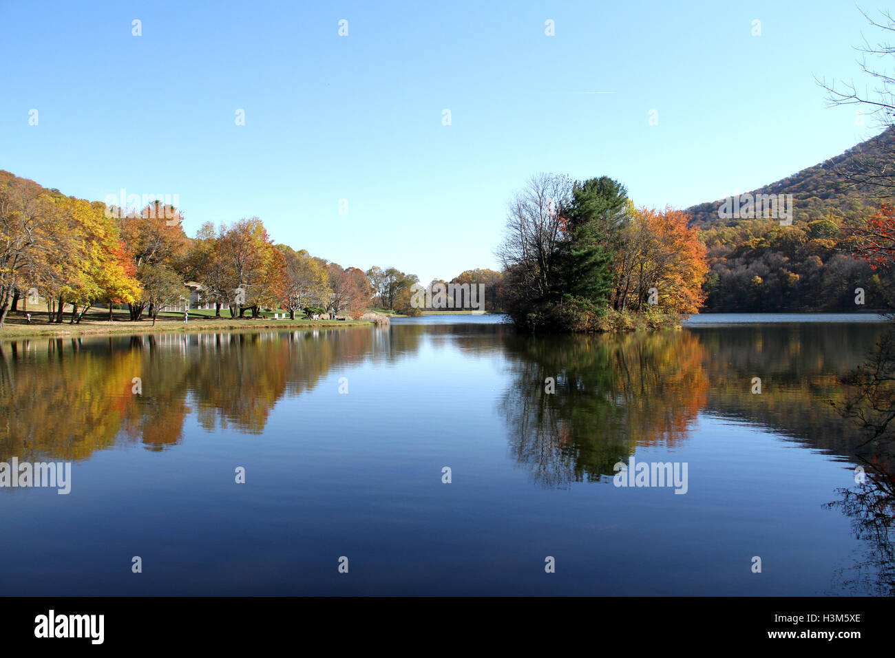Virginia, USA. View of Abbott Lake with trees on island, in autumn ...