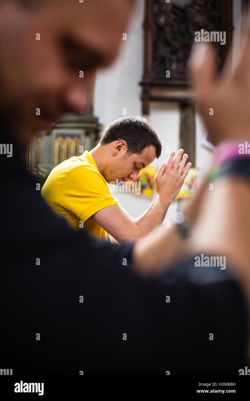 Handsome young man praying in a church Stock Photo - Alamy