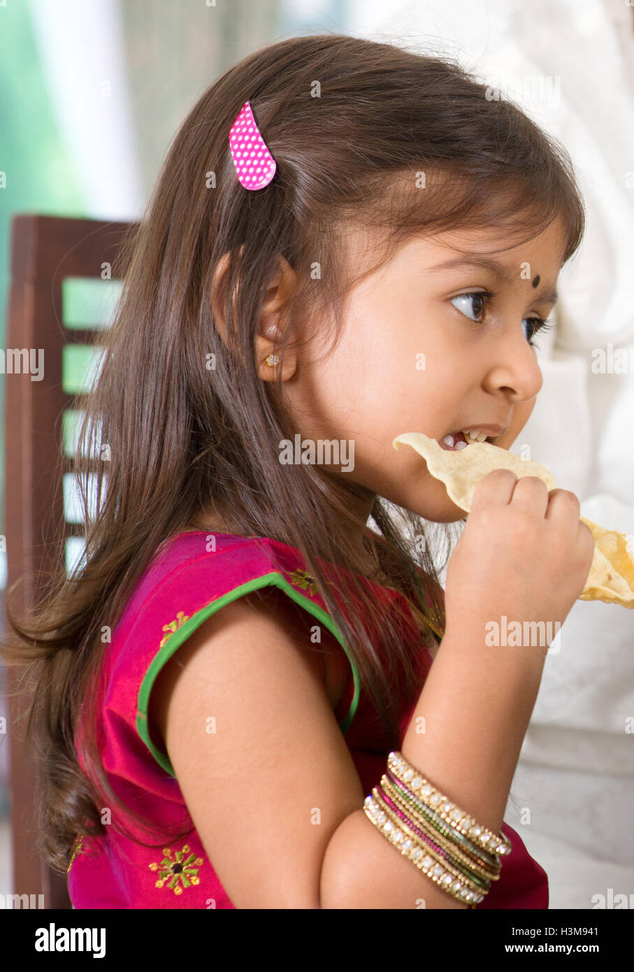 Indian girl eating snack Stock Photo - Alamy