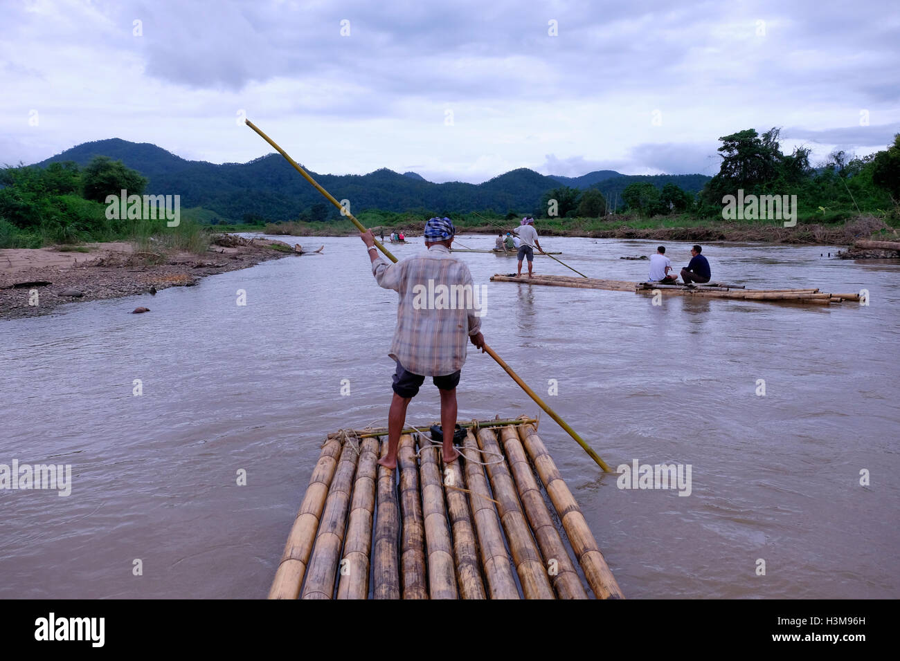 A Thai man rowing a handmade bamboo raft at the Pai river in Mae Hong ...