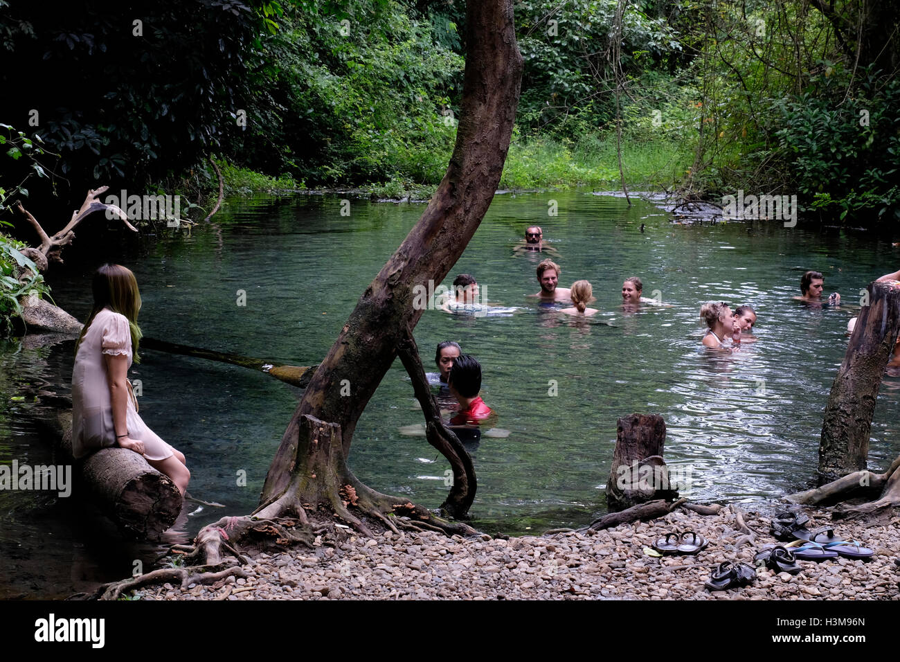 Tourists bathing in the shallow lagoon of Sai Ngam Hot Springs ...